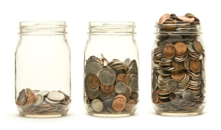 Three coin savings jars each fuller than the last